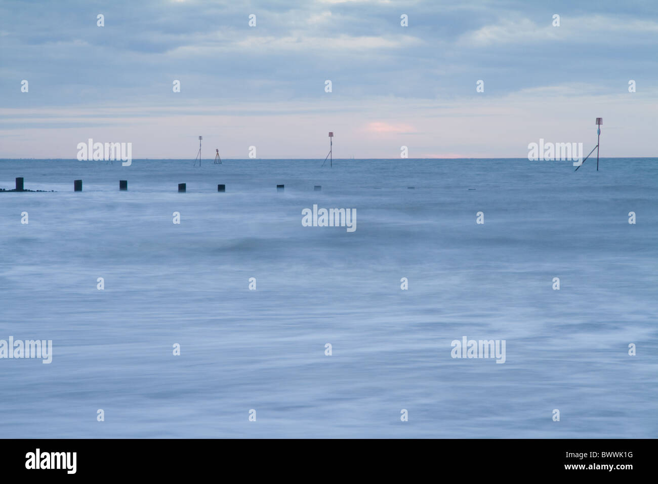 The sea swirls round a groyne and shore-line markers on Hunstanton ...