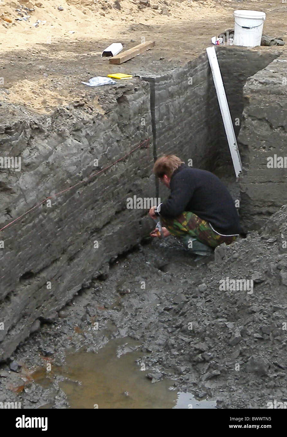 Happisburgh archaeological dig, person digging in trench on beach, at ...