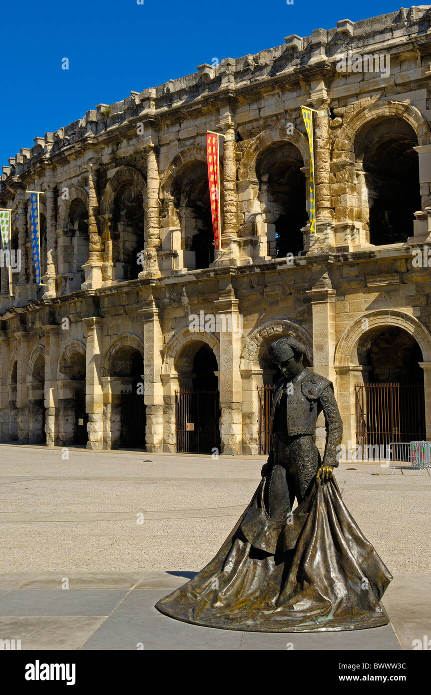 Roman amphitheatre and bullfighter statue. Arénes, Nimes, Gard. Bouches ...