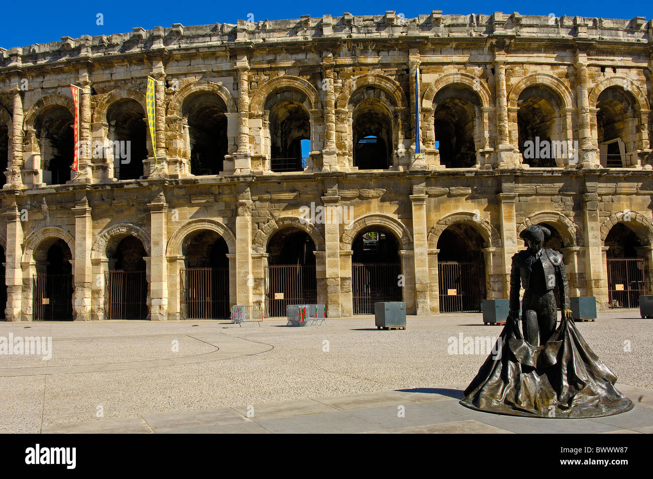 Roman amphitheatre and bullfighter statue. Arénes, Nimes, Gard. Bouches ...