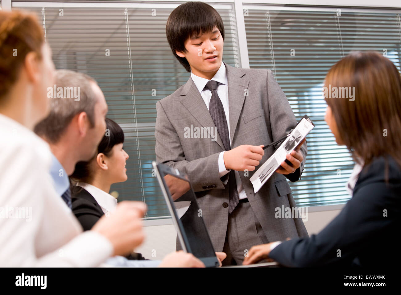 Photo of confident leader pointing at paper with diagrams during ...