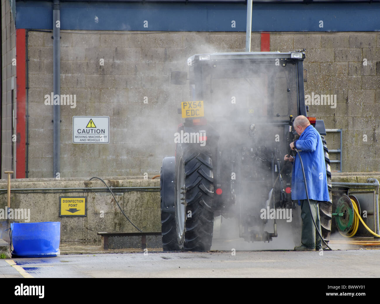 Pressure washing tractor disinfection point Stock Photo - Alamy