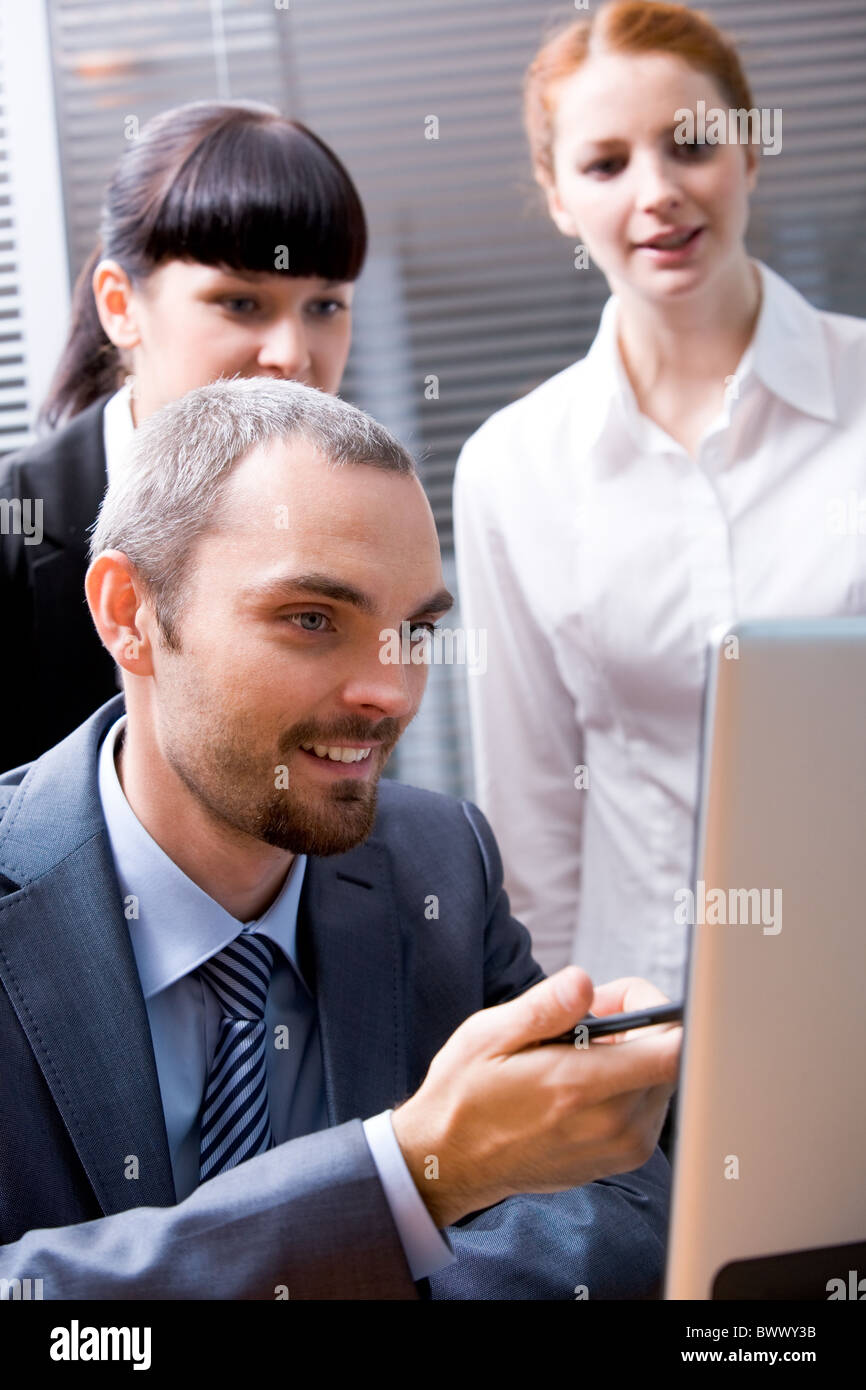 Portrait of confident boss pointing at laptop screen during briefing ...