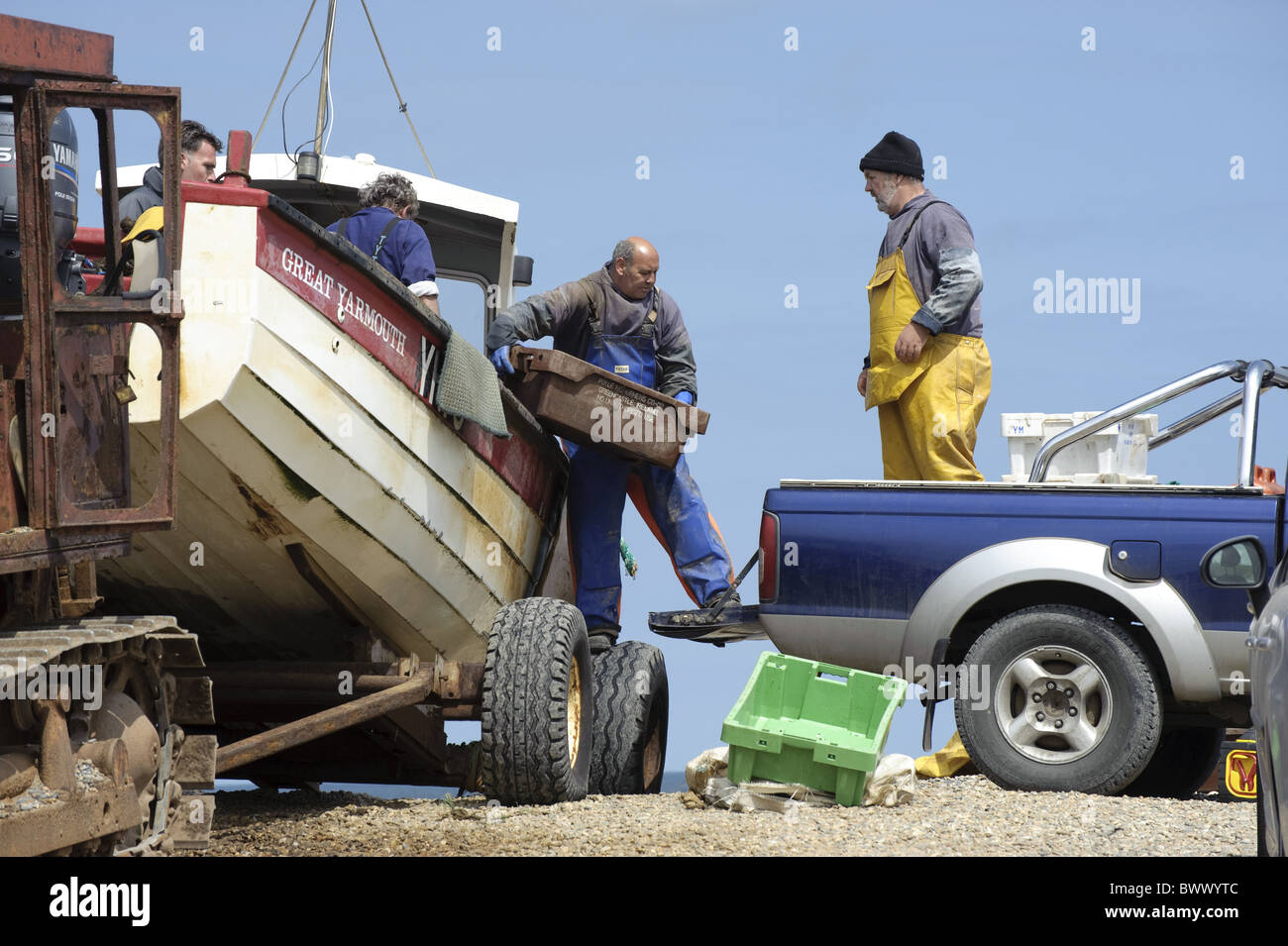 Fishermen unloading fishing boat beach Weybourne Stock Photo - Alamy