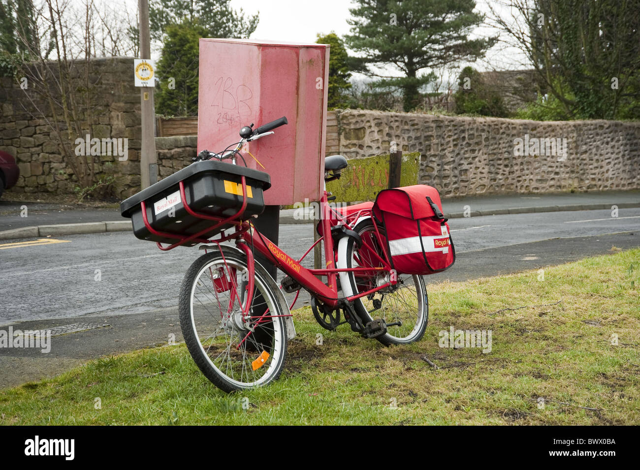 Postmans bicycle leaning against postbox Stock Photo - Alamy