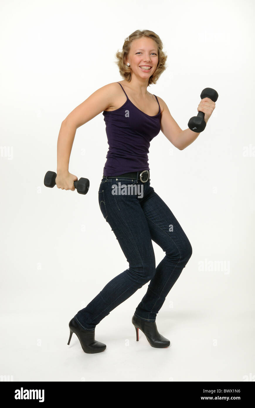 Young woman using dumbbells, smiling, feeling good Stock Photo - Alamy