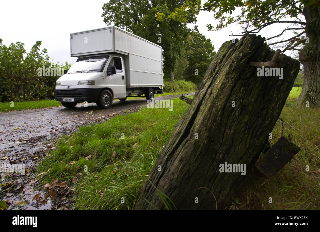 White box van driving through narrow country lane in rural Wales UK ...