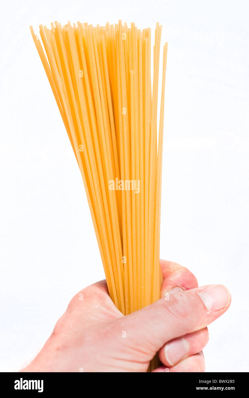 many spaghetti in one hand on a white background Stock Photo - Alamy