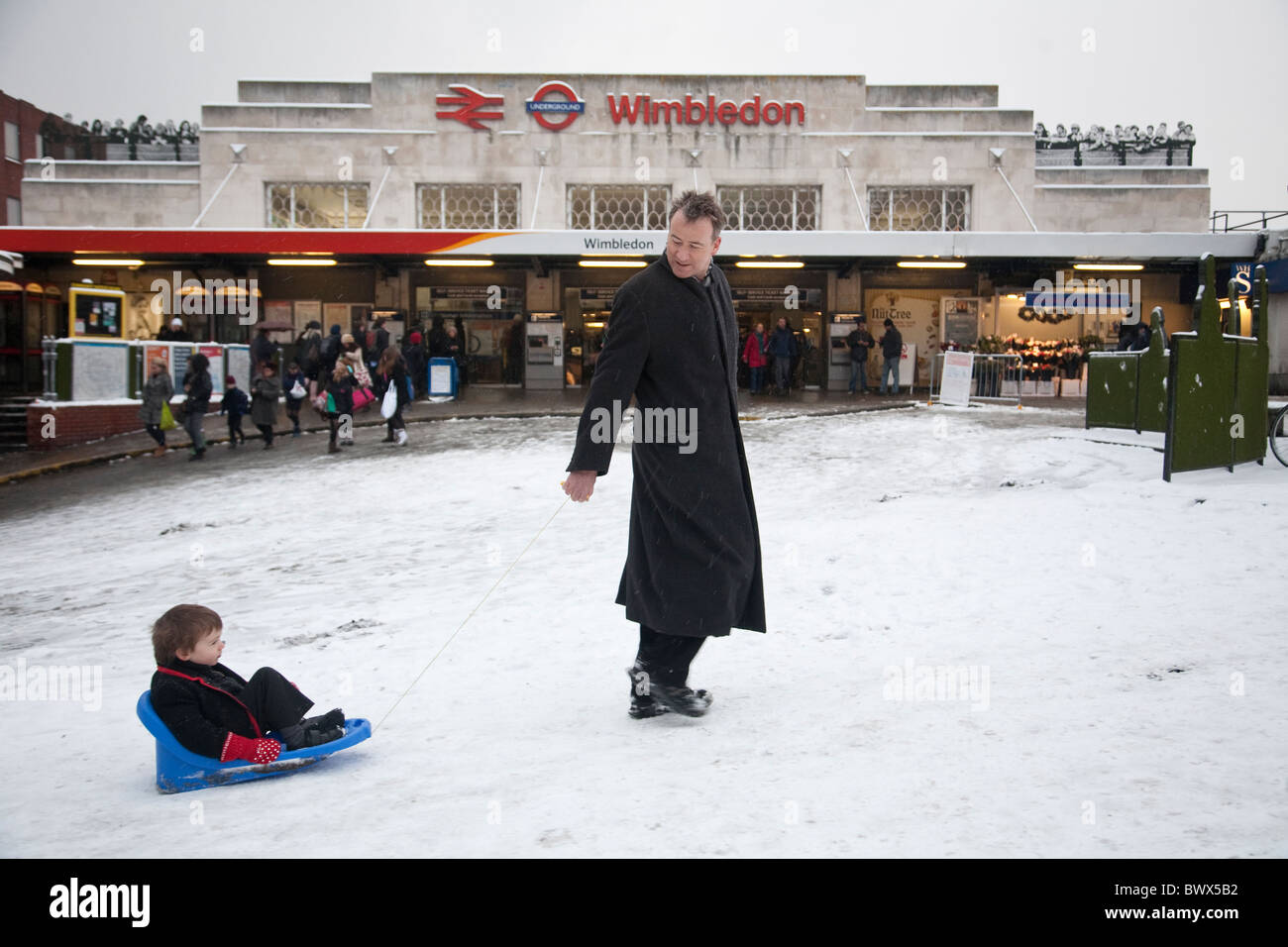 Father and son in the early winter snow in Wimbledon, freezing ...