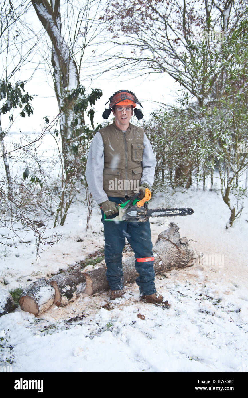 Tree surgeon with a chainsaw in the snow, Hattingley, Hampshire ...