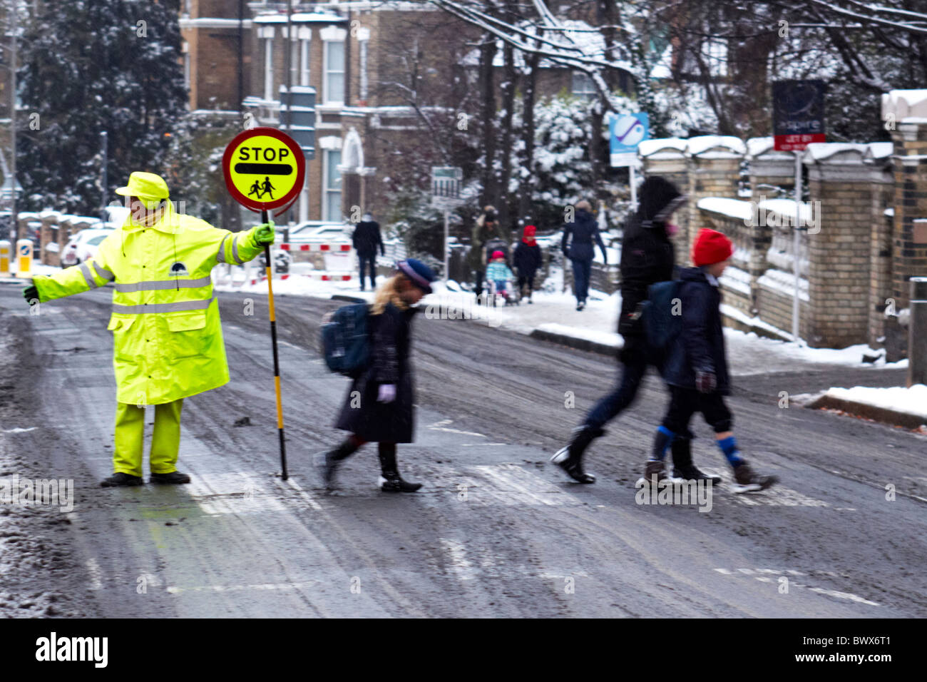 LONDON, UK. Local 'lollipop man' helps school children cross the road ...