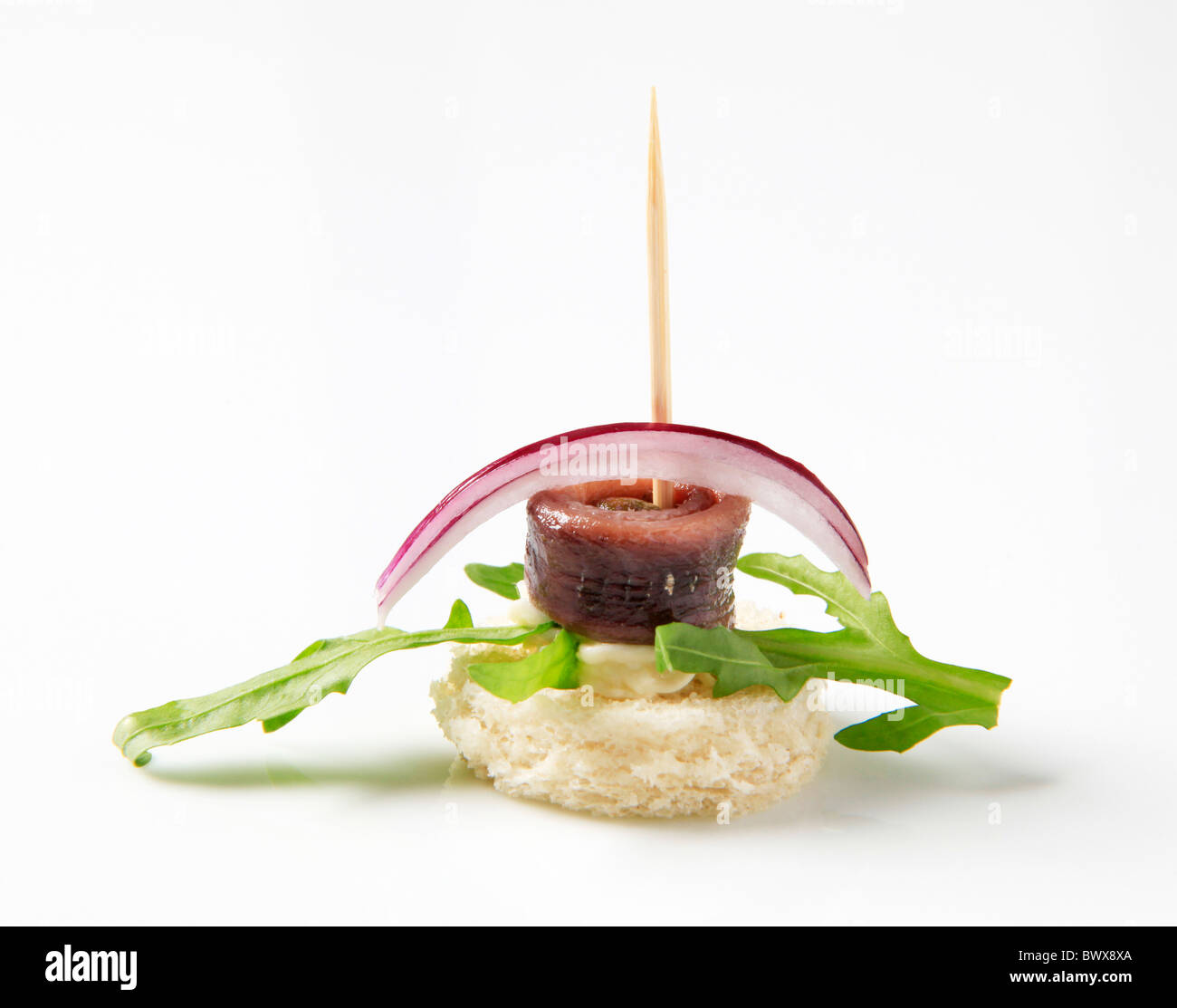 Anchovy canape garnished with arugula and onion Stock Photo - Alamy