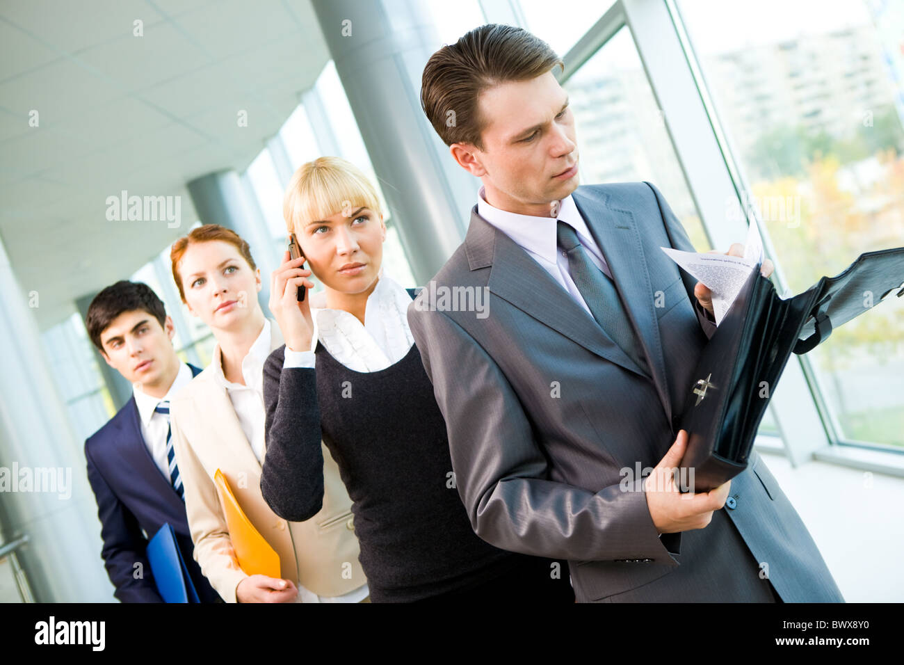 Portrait of business group standing in line and doing work Stock Photo ...