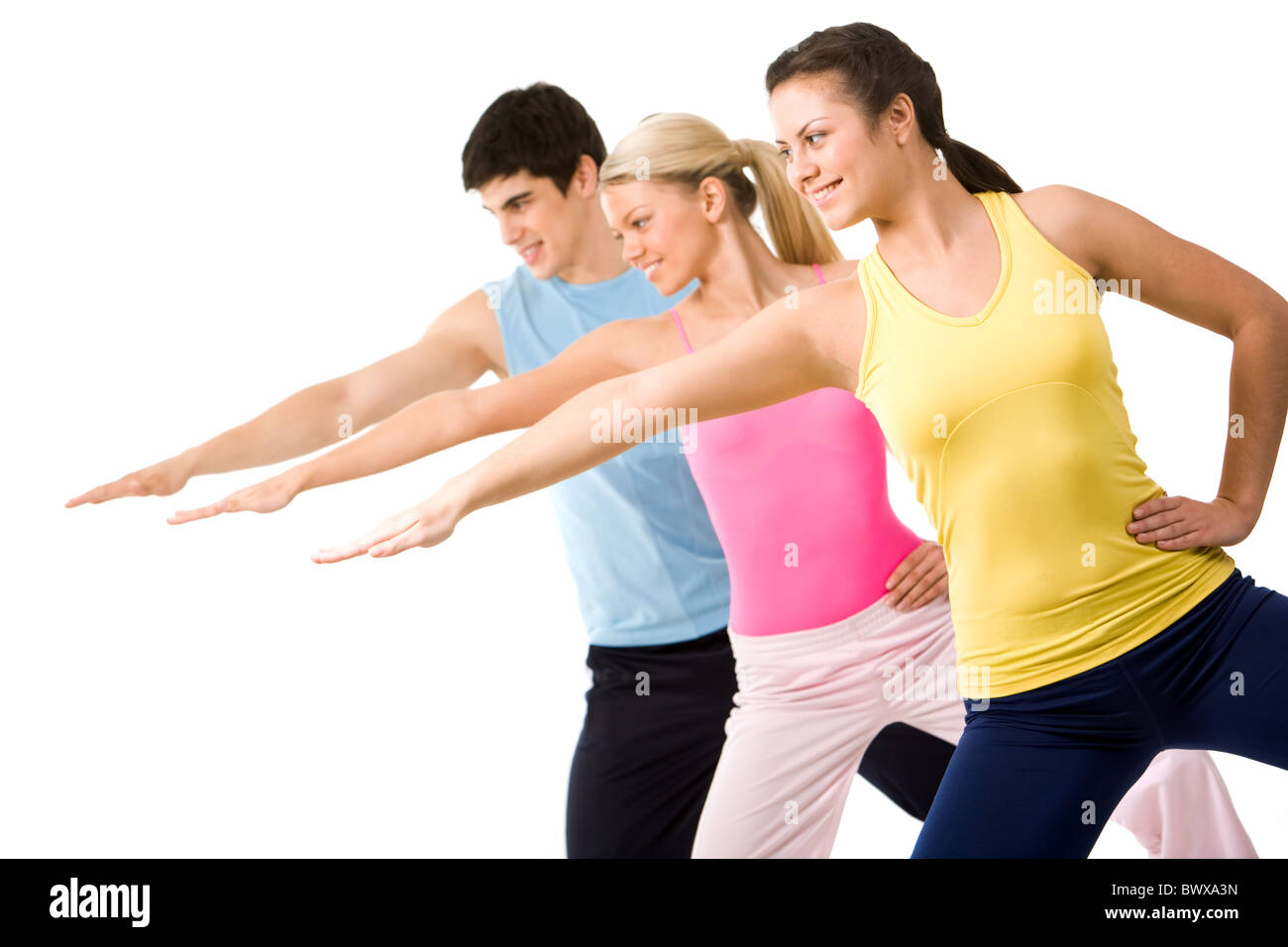 Portrait of young sporty people doing physical exercise altogether ...