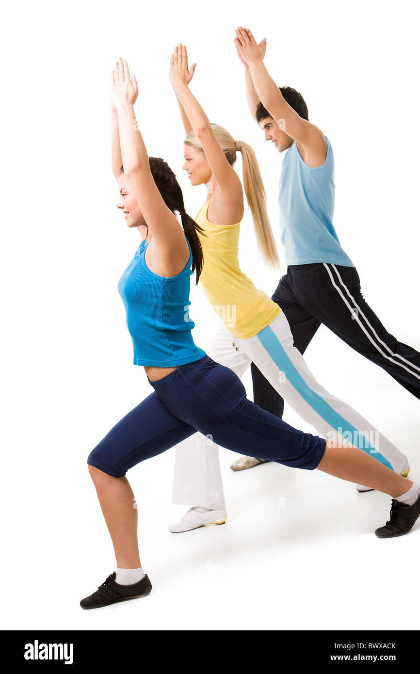 Portrait of young sporty people doing physical exercise altogether ...