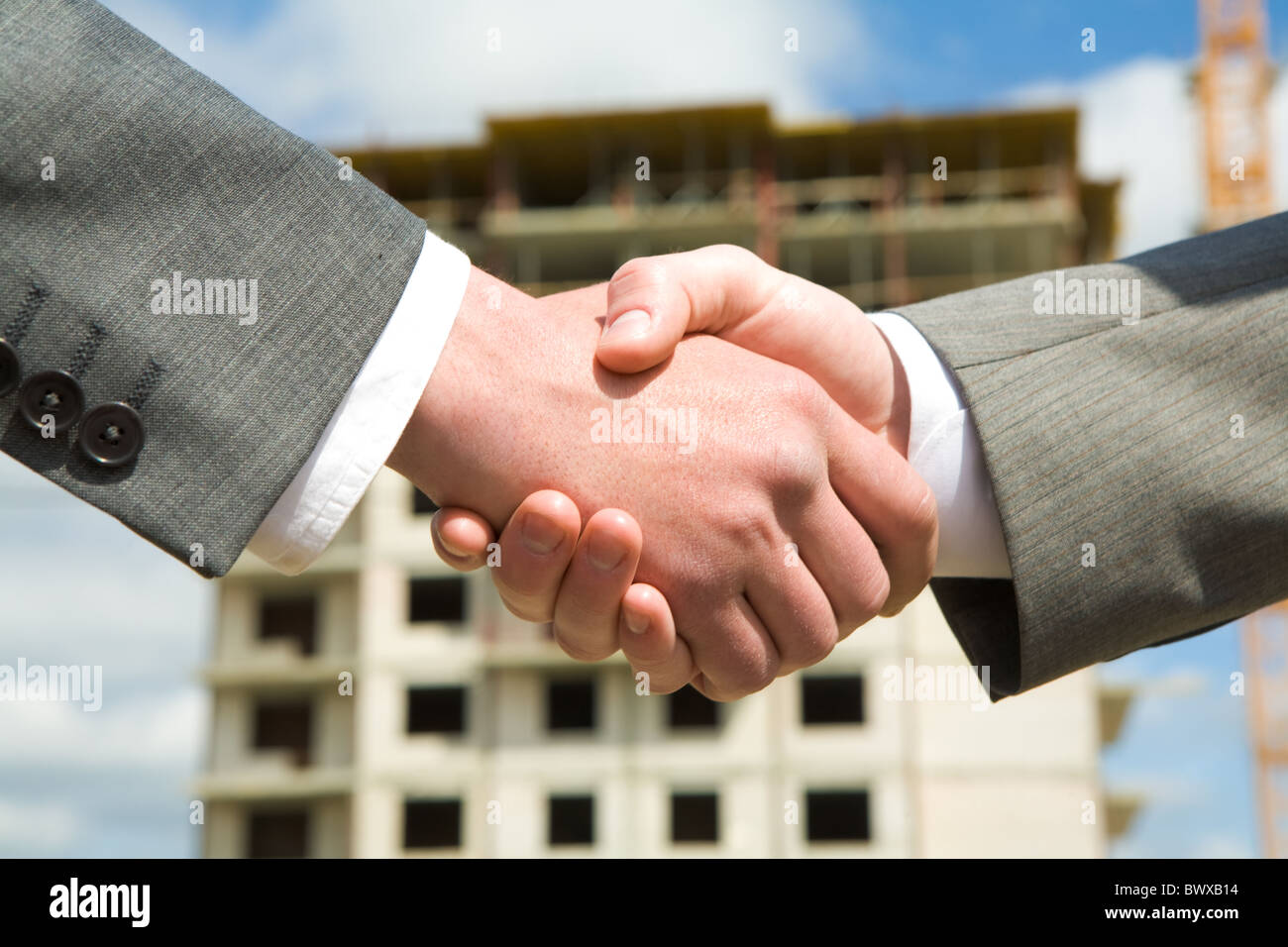 Handshake under corporate building hi-res stock photography and images ...
