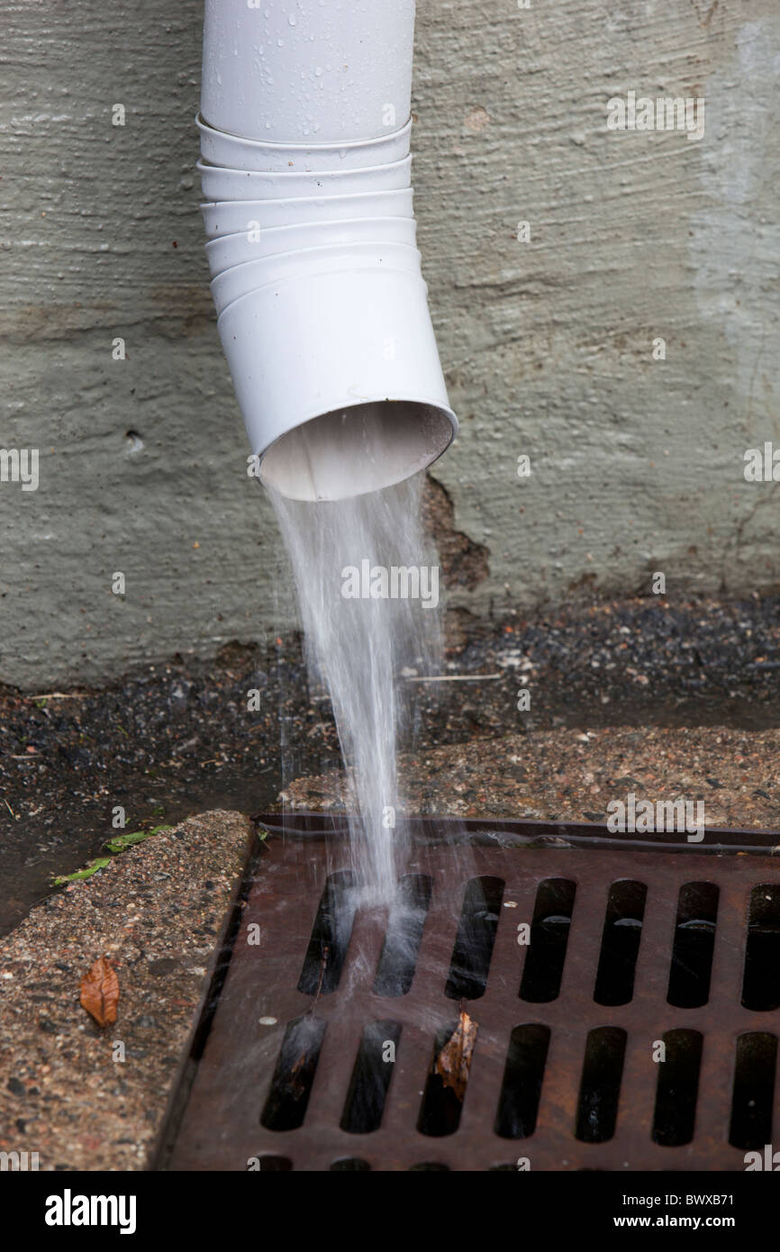 Downspout spewing water to drain Stock Photo - Alamy