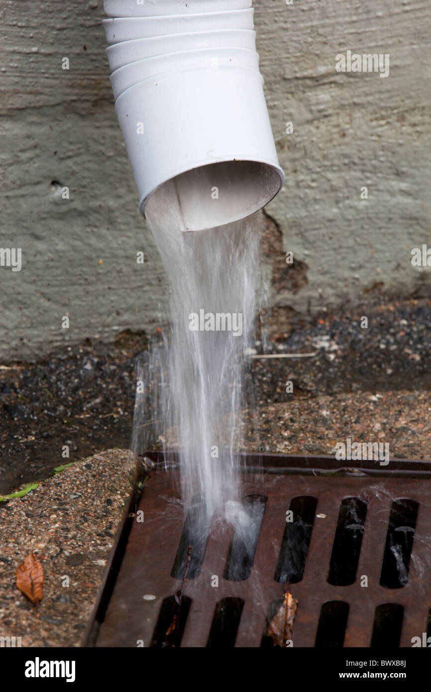 Downspout spewing water to drain Stock Photo - Alamy