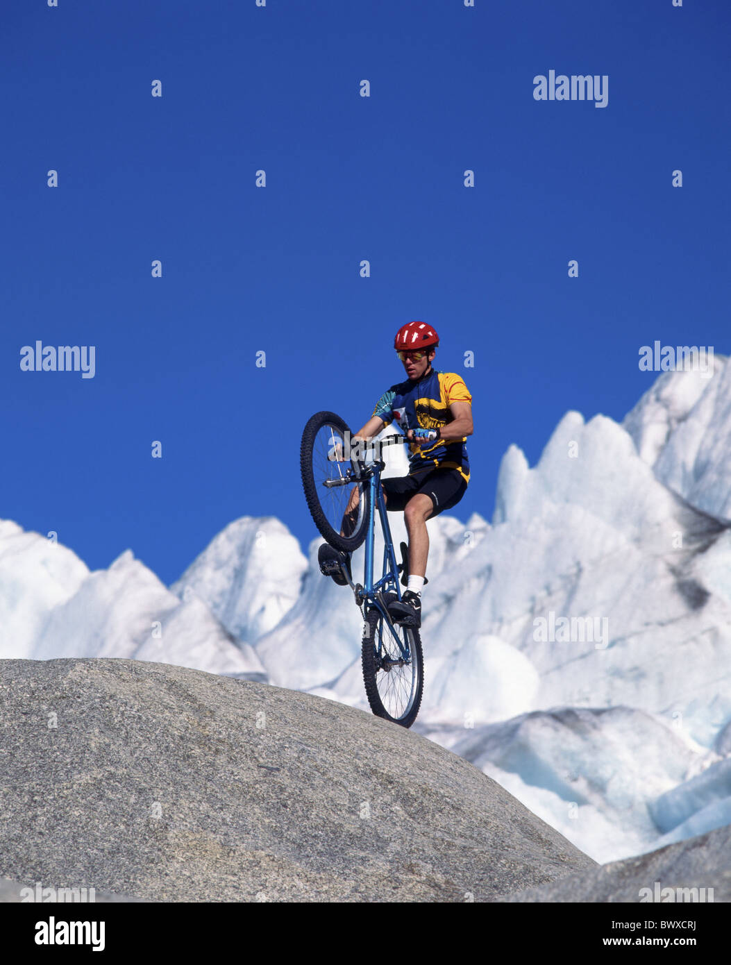 Switzerland blue sky dynamic cliff man mountain bike snow masses jump ...