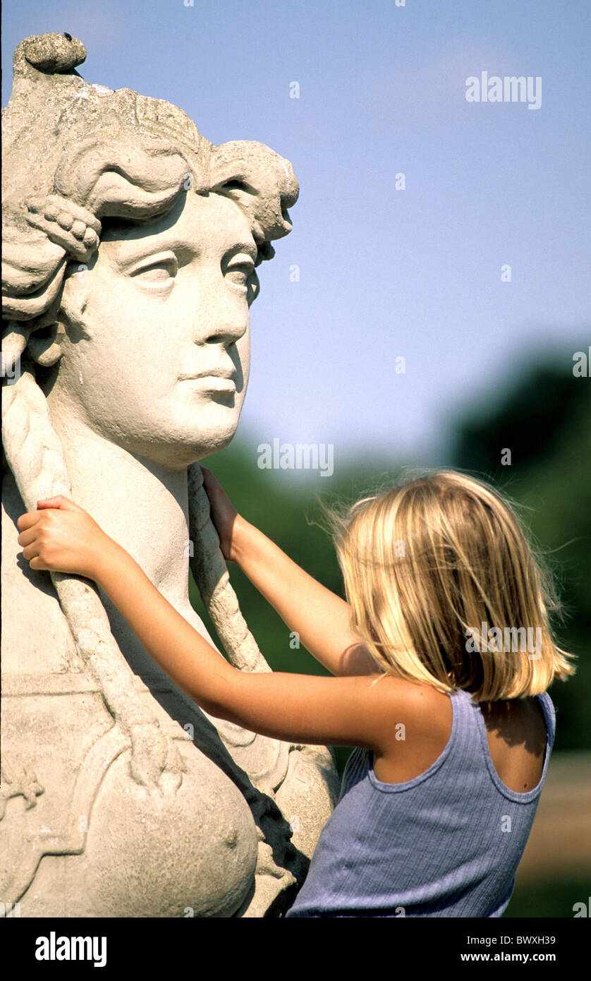 child plays games outside girls climbing statue sandstone Austria ...