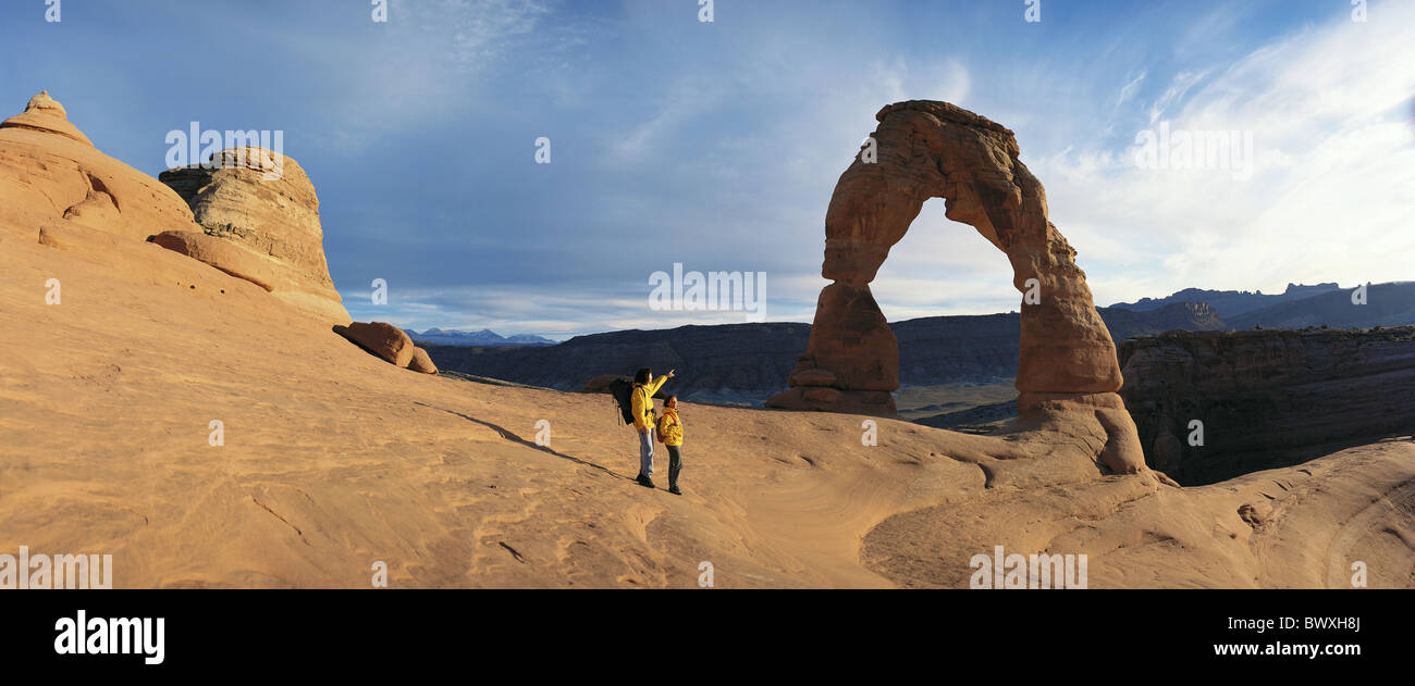Arches national park curve rock cliff scenery pair couple tourist USA ...