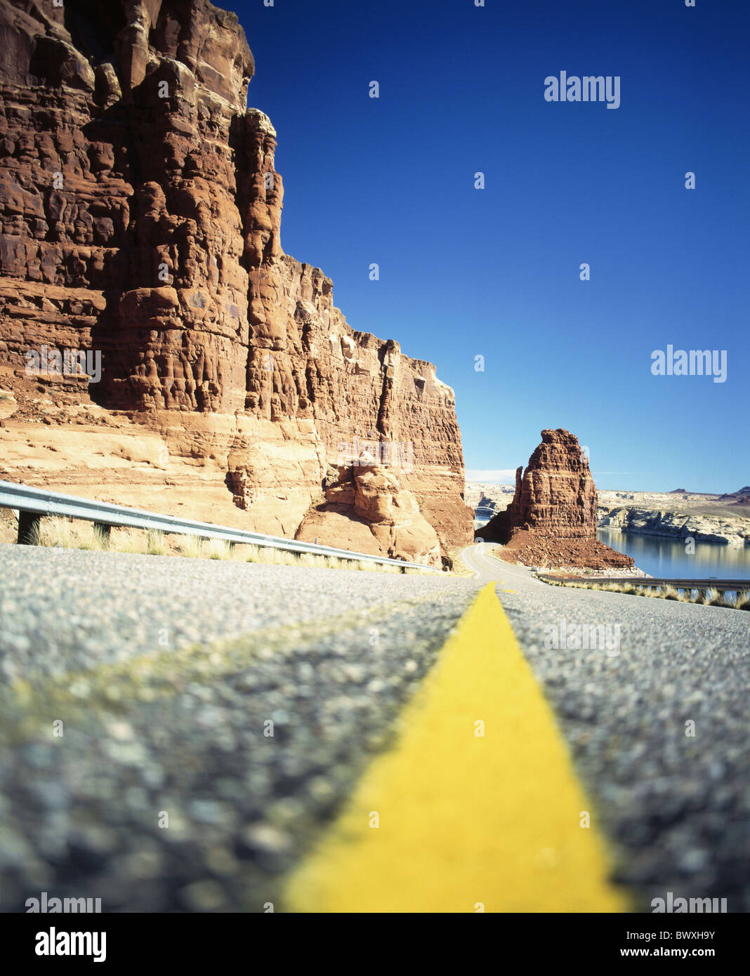 highway lake Powell guardrails center line yellow red rocks cliffs USA ...