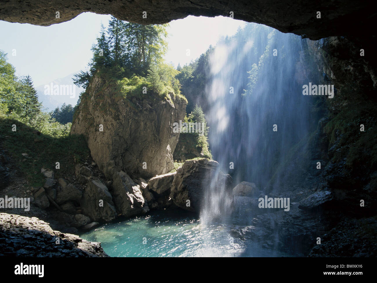 waterfall lake sea rock cliff look glance from cave back light ...
