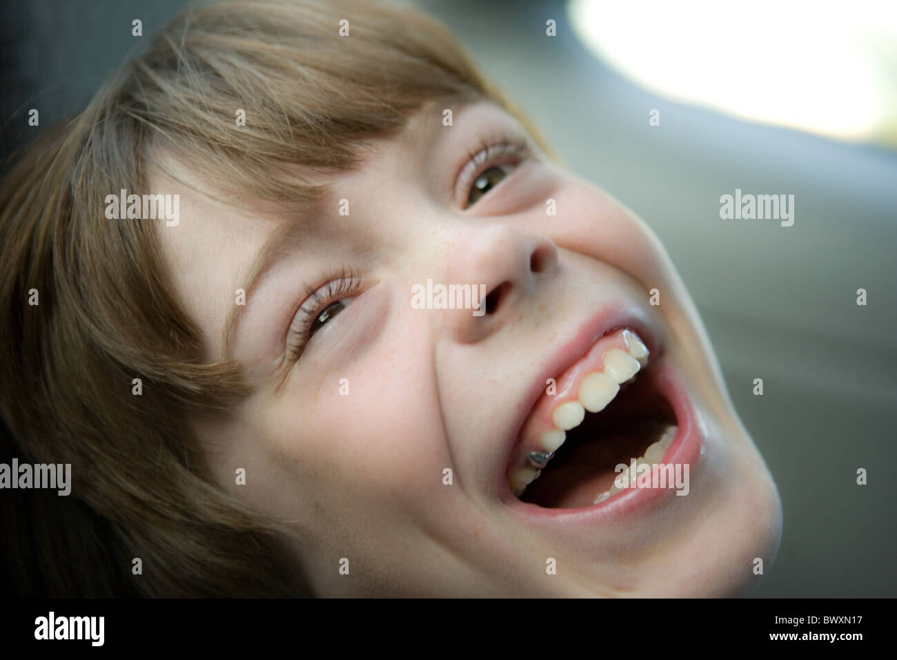 Eight year old child laughing in window light, close up Stock Photo - Alamy