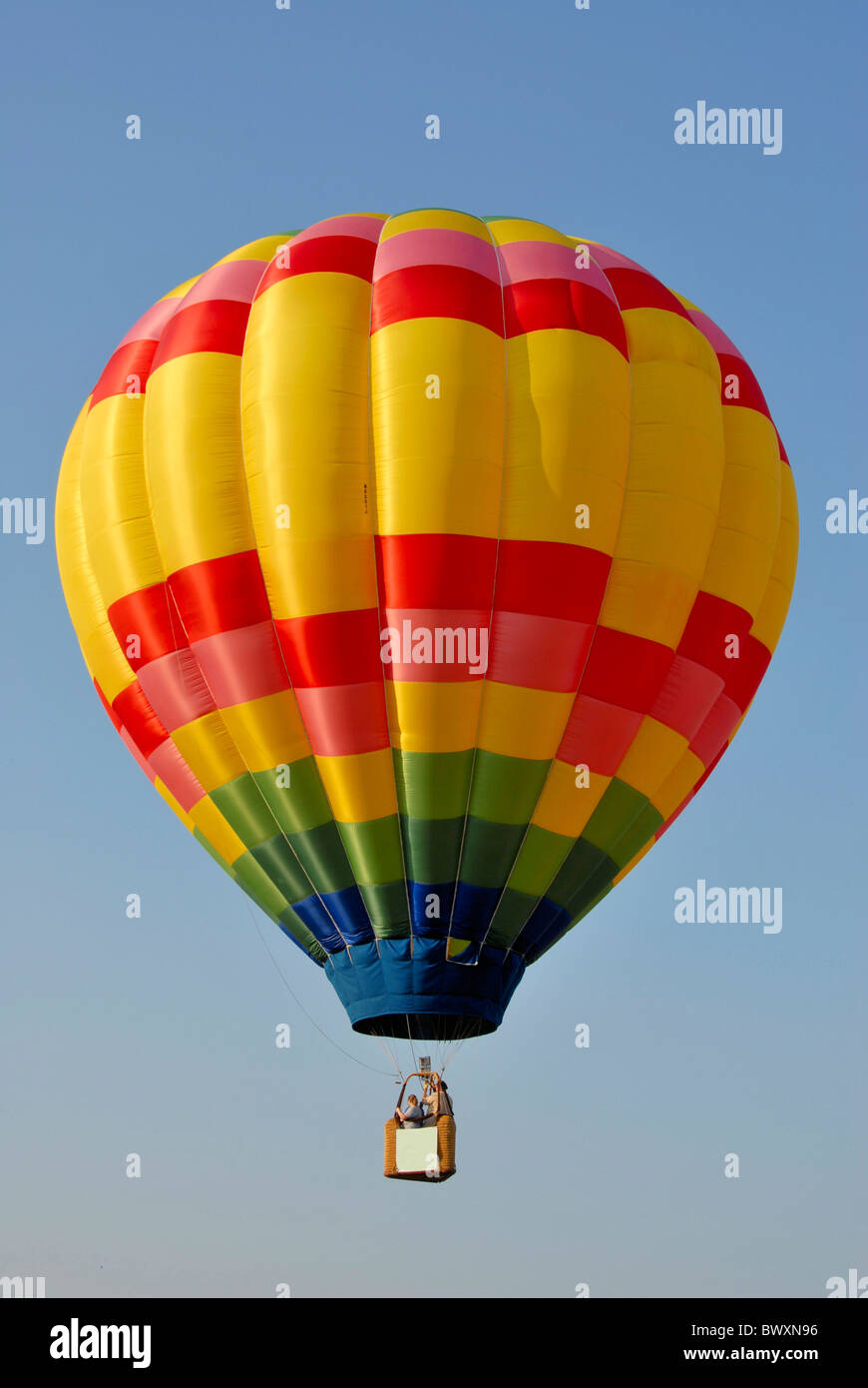 A red yellow green colorful helium hot air balloon flying against a ...