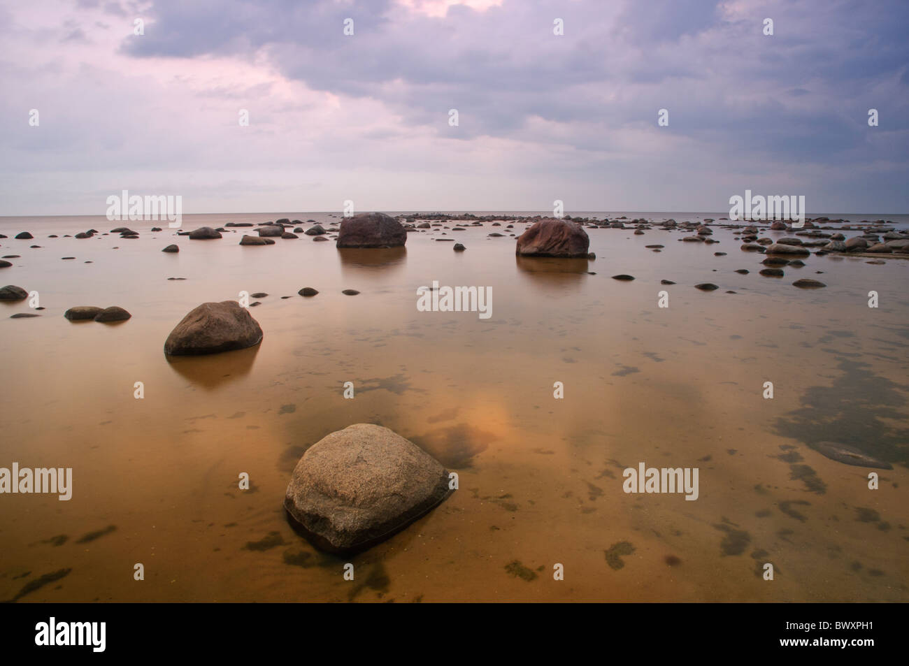 Evening landscape with rocks in a calm shallow water Stock Photo - Alamy