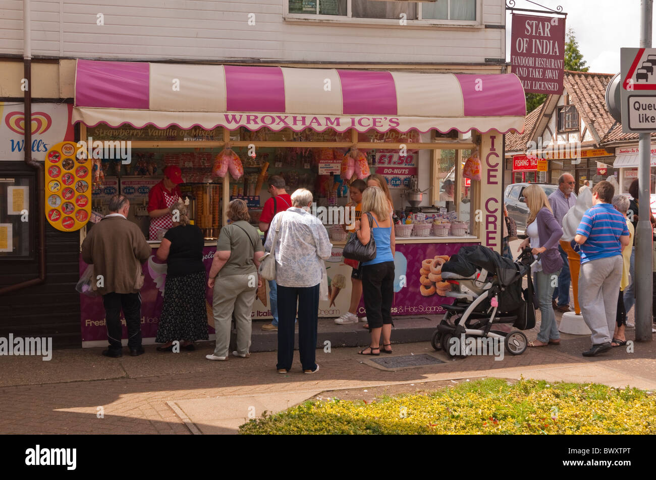 People buying ice creams at a kiosk in the high street in Wroxham ...