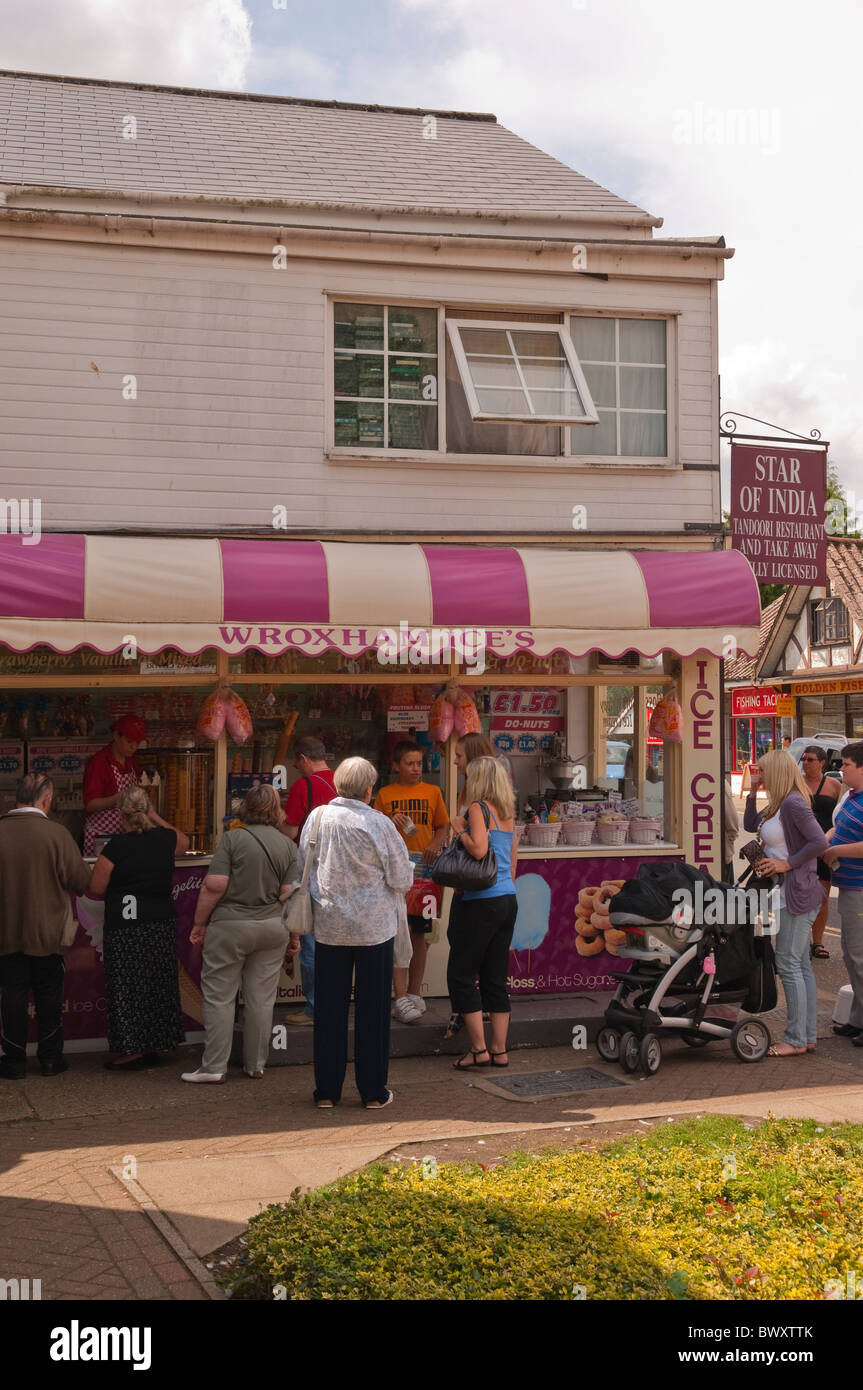 People buying ice creams at a kiosk in the high street in Wroxham ...