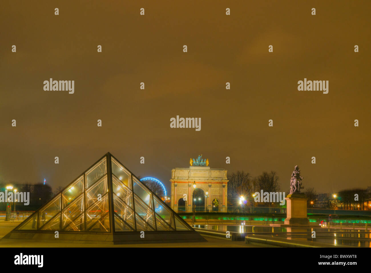 The Louvre courtyard - a pyramid and Arc de Triomphe du Carrousel Stock ...