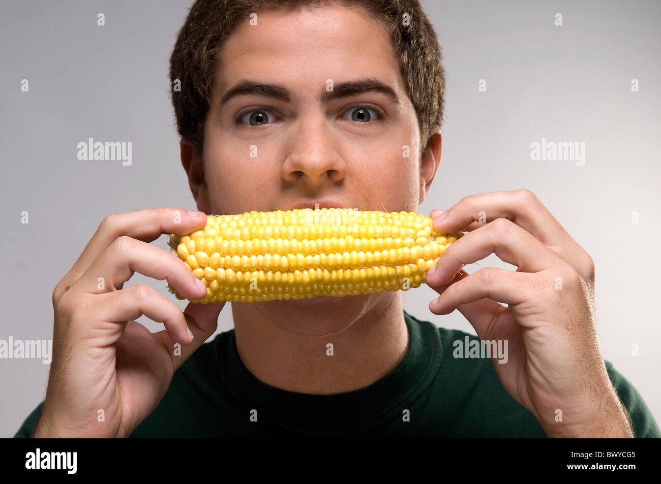 Portrait of a man eating a corn Stock Photo - Alamy