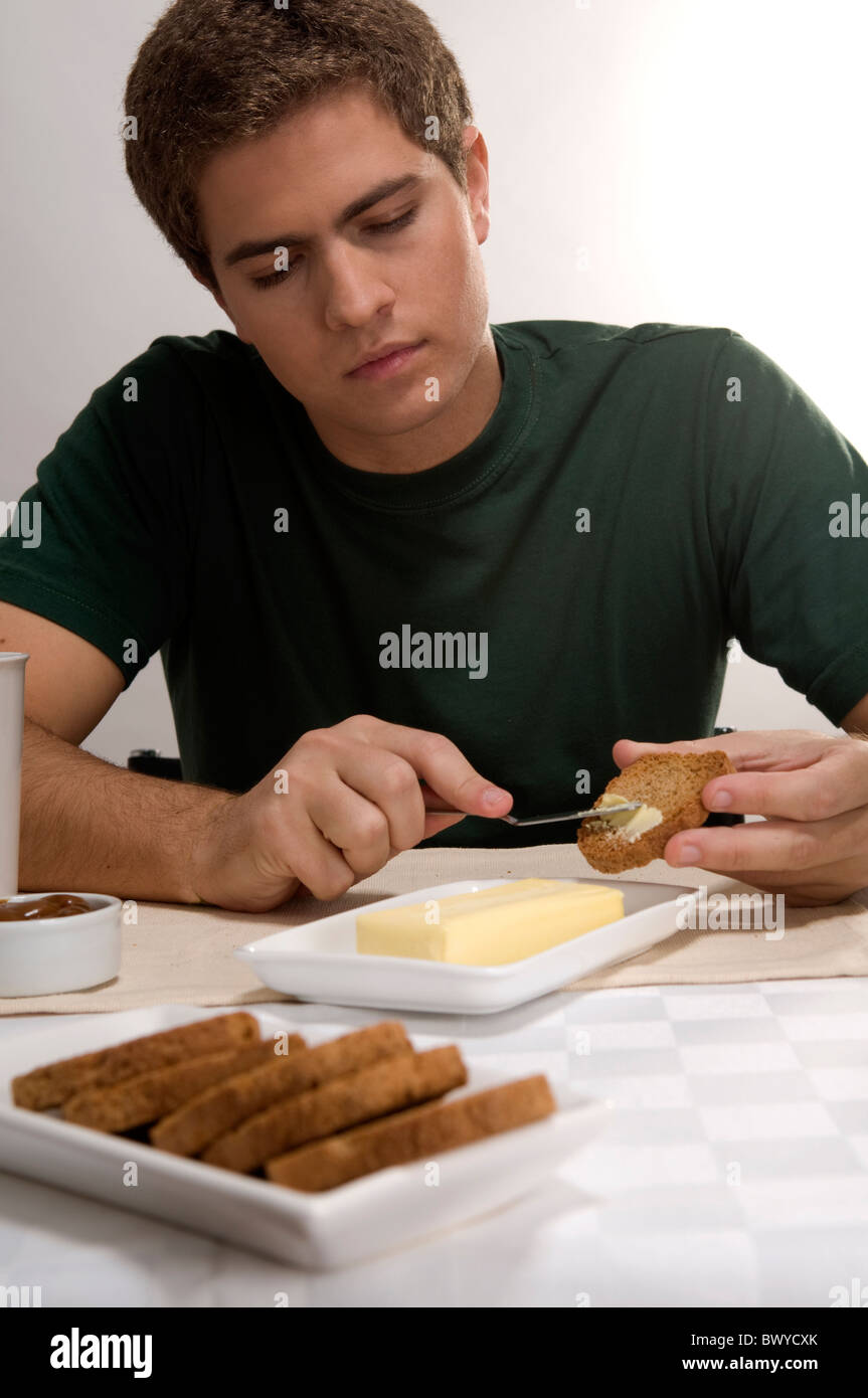 Man spreading butter on a toast Stock Photo - Alamy