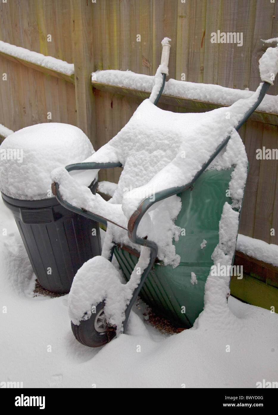 Snow-covered Wheelbarrow and Garden Dustbin, UK Stock Photo - Alamy