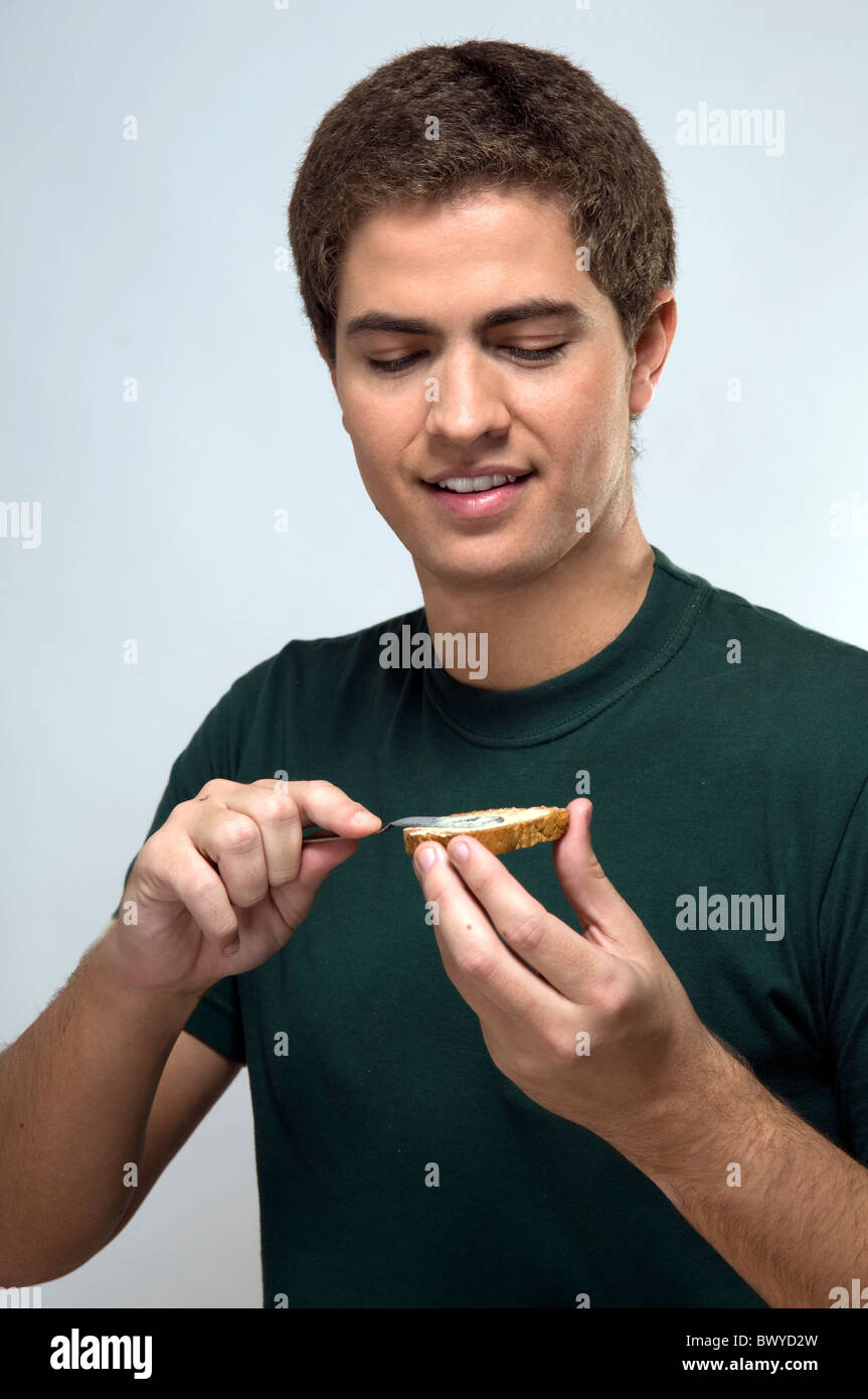 Man spreading butter on a toast Stock Photo - Alamy