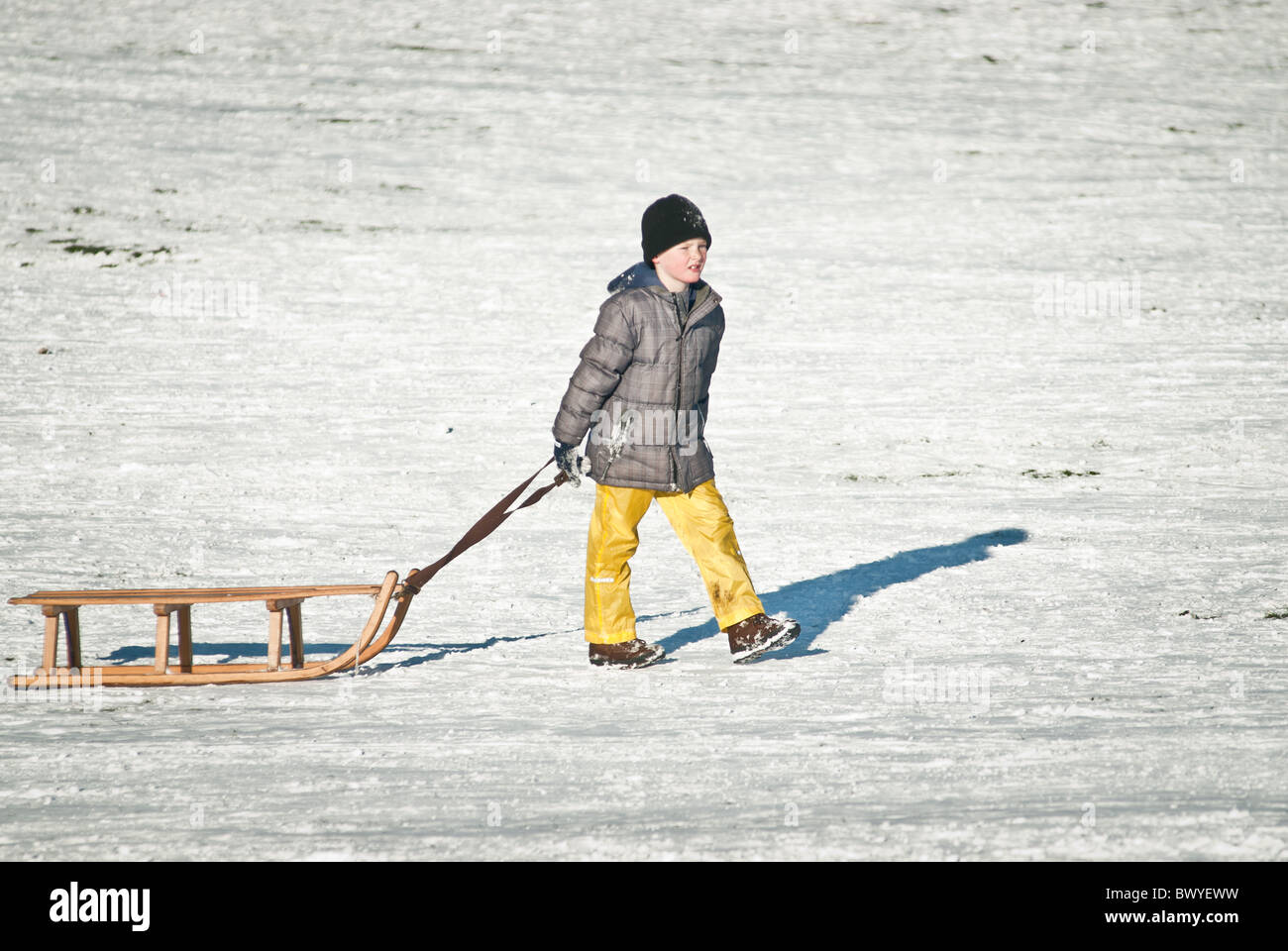 Boy pulling sledge Stock Photo - Alamy