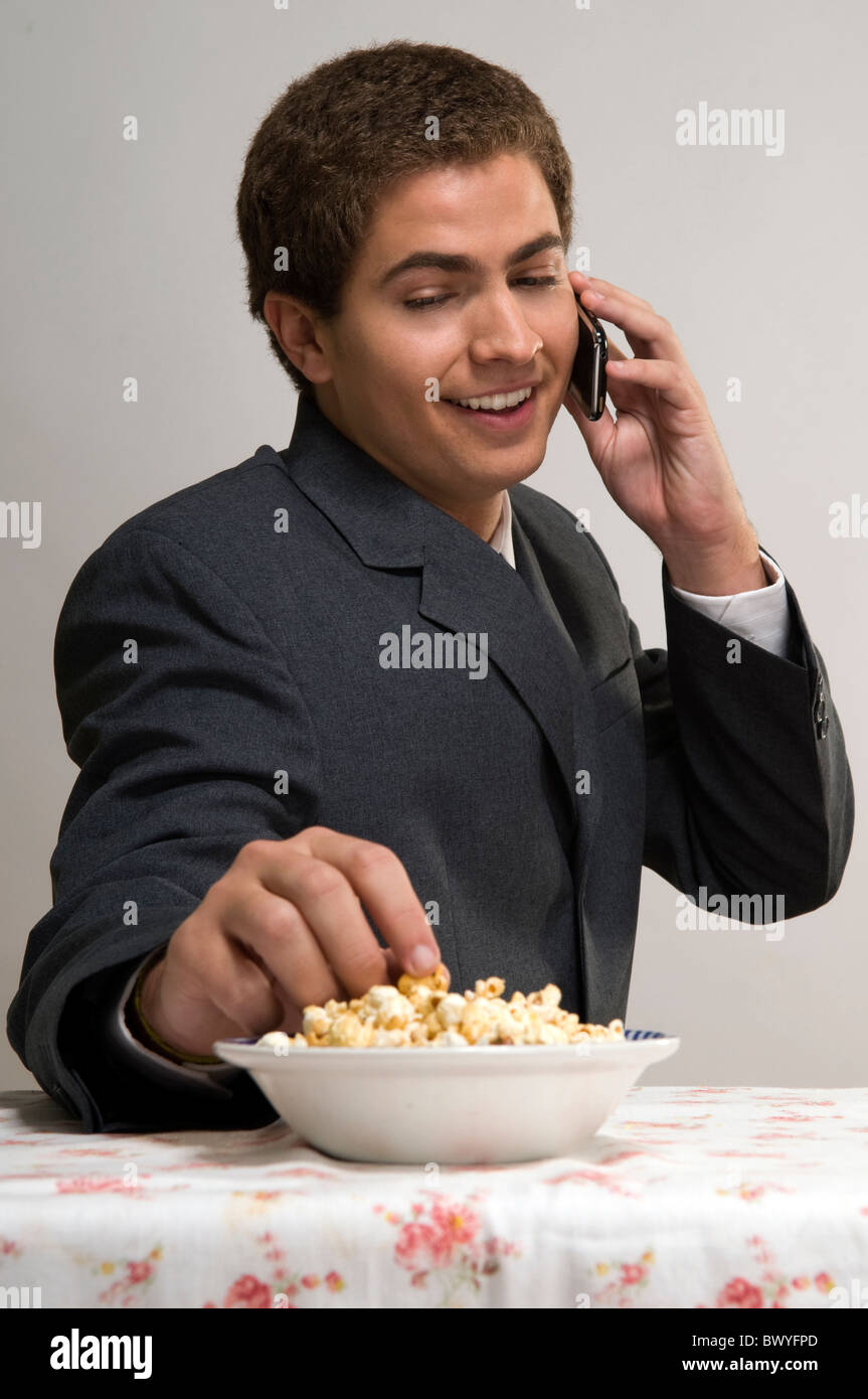 Man eating popcorn and talking on phone Stock Photo - Alamy