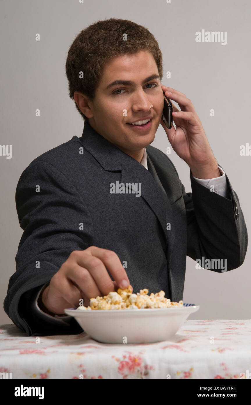 Man eating popcorn and talking on phone Stock Photo - Alamy