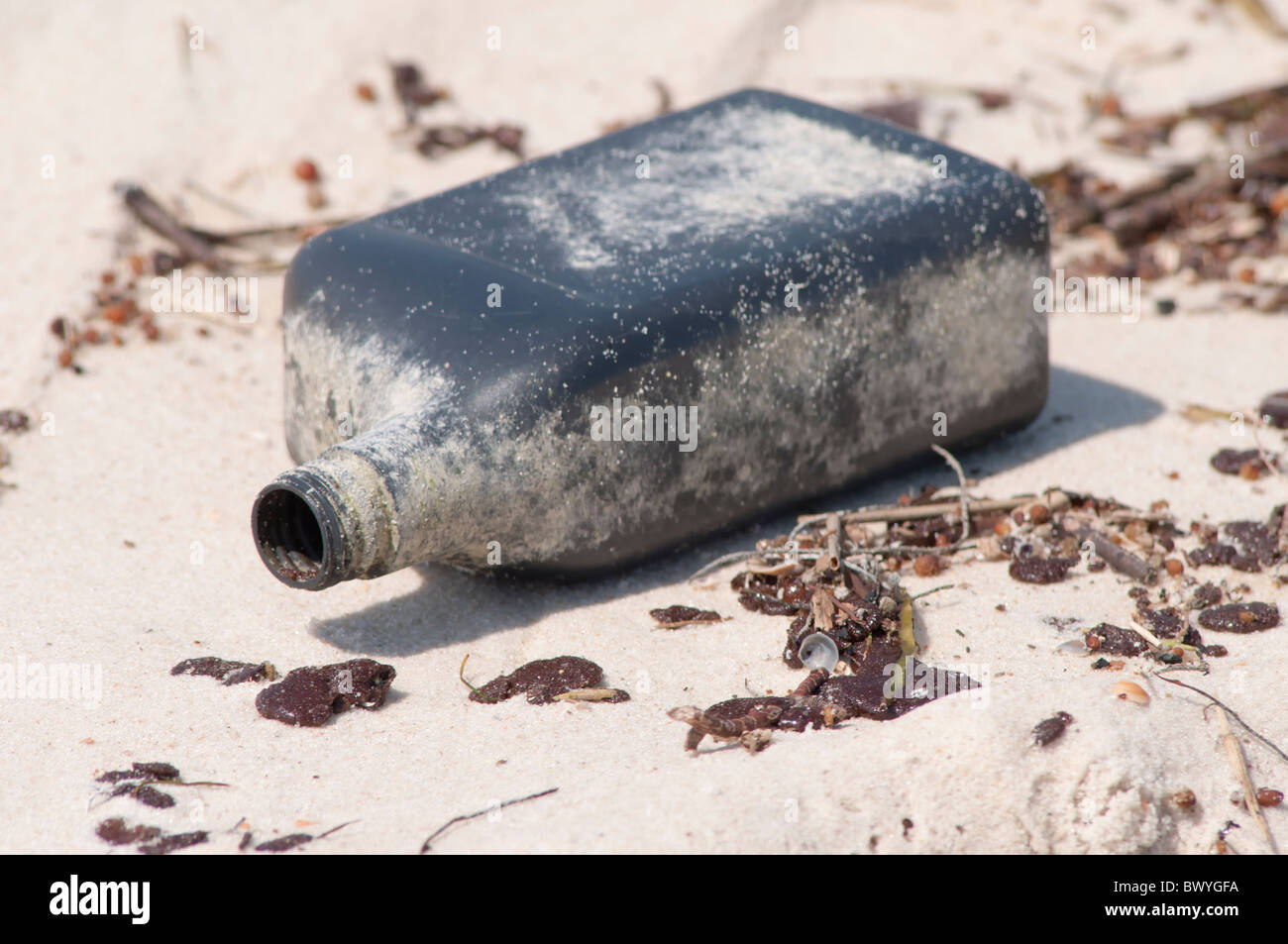 Empty oil container surrounded by tar balls on the beach, Fort Morgan ...