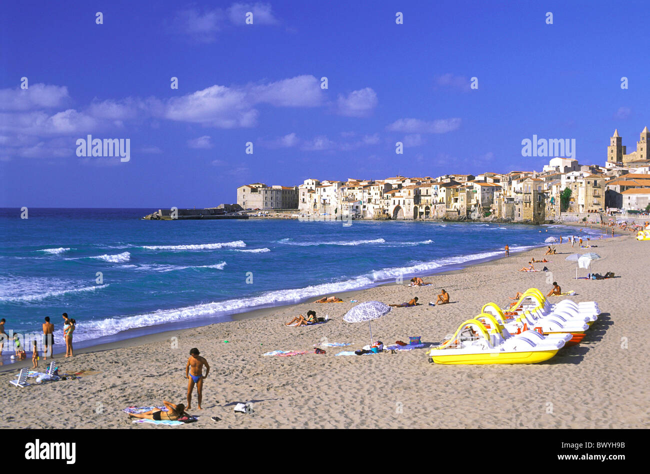 Old Town bathers bathing beach Cefalu Italy Europe coast sea Pedalos ...