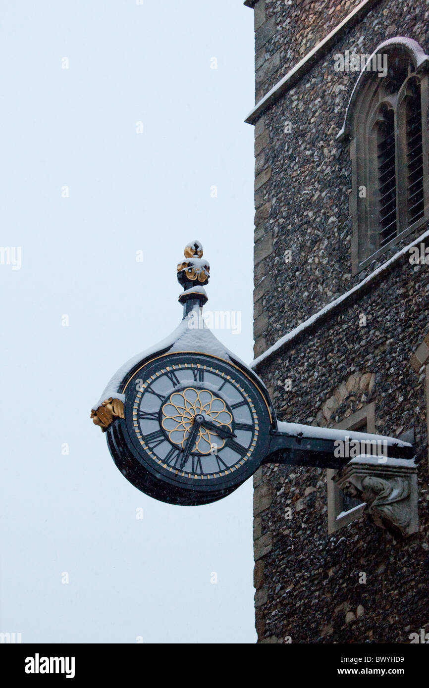Large town clock on tower in Canterbury high street. With snow on top ...