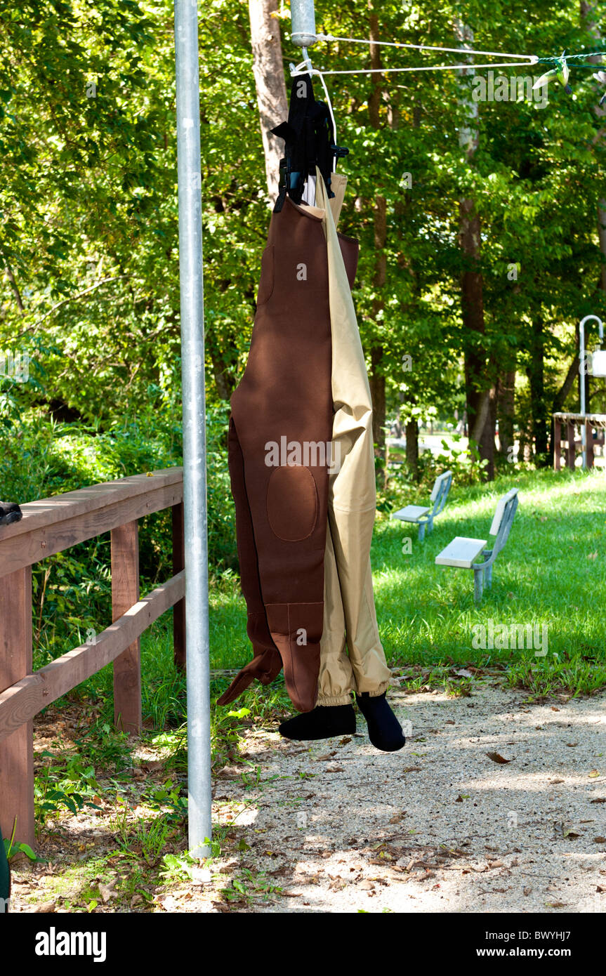 two pairs of fishing waders hang from a pole in Arkansas, USA Stock ...