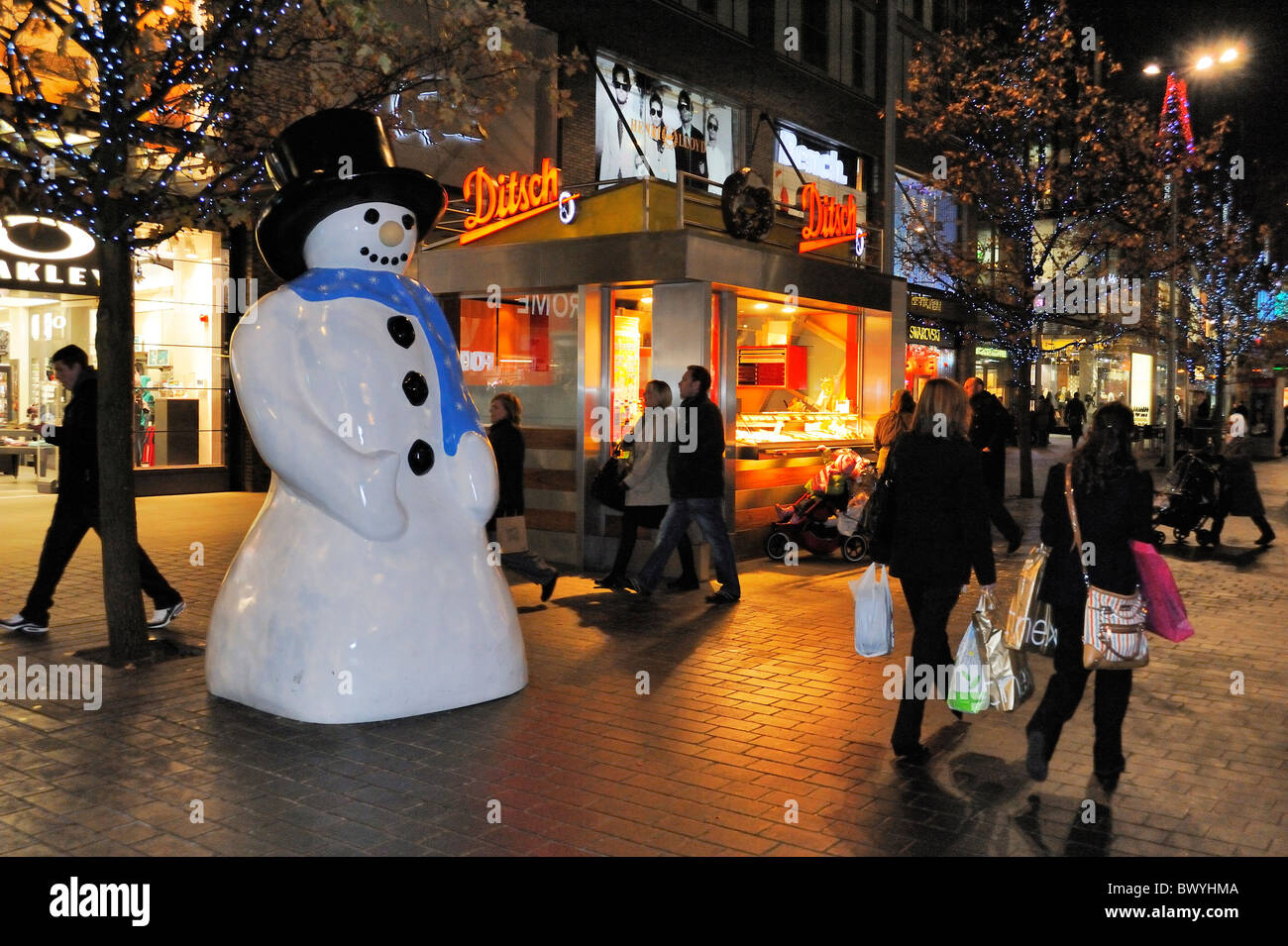 Christmas shoppers in Liverpool One walking past a large model of a ...