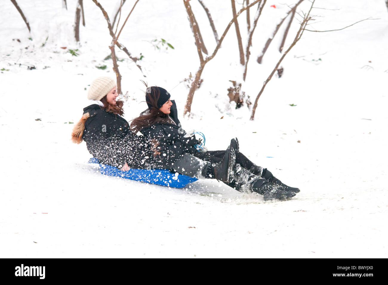 Girls riding on a sled Stock Photo - Alamy