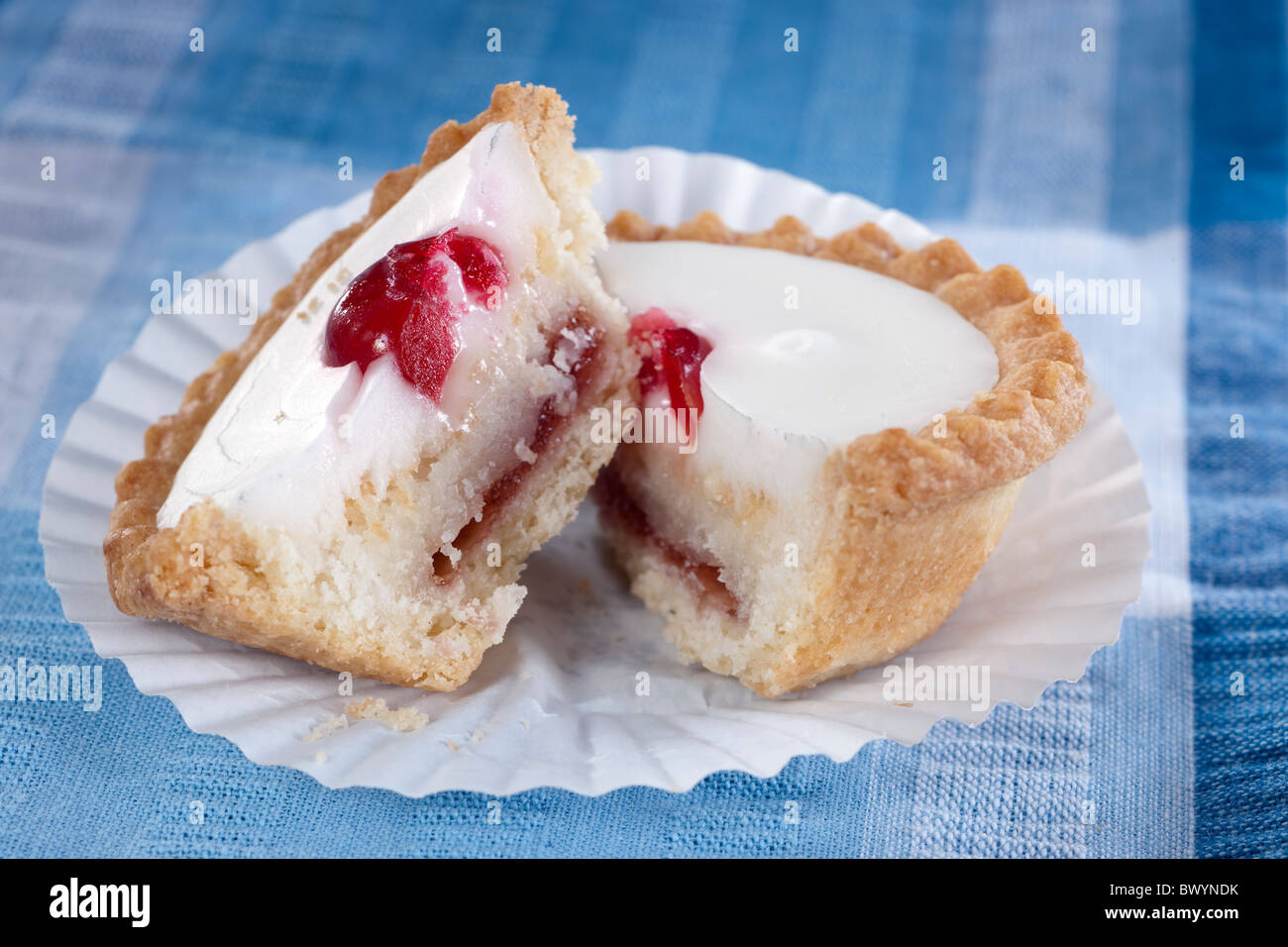 Small bakewell cake cut into two Stock Photo - Alamy