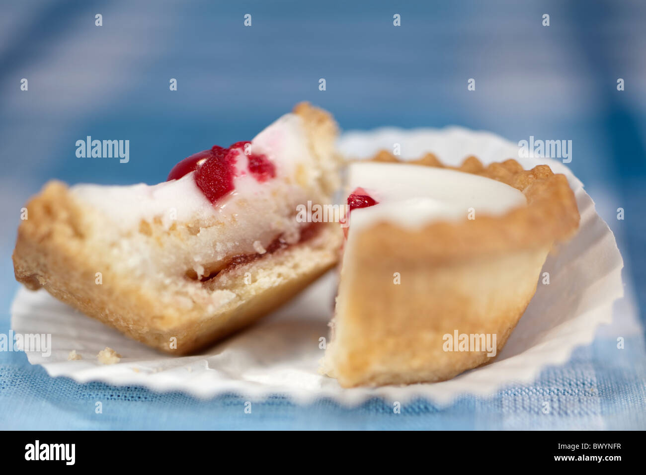 Small bakewell cake cut into two Stock Photo - Alamy