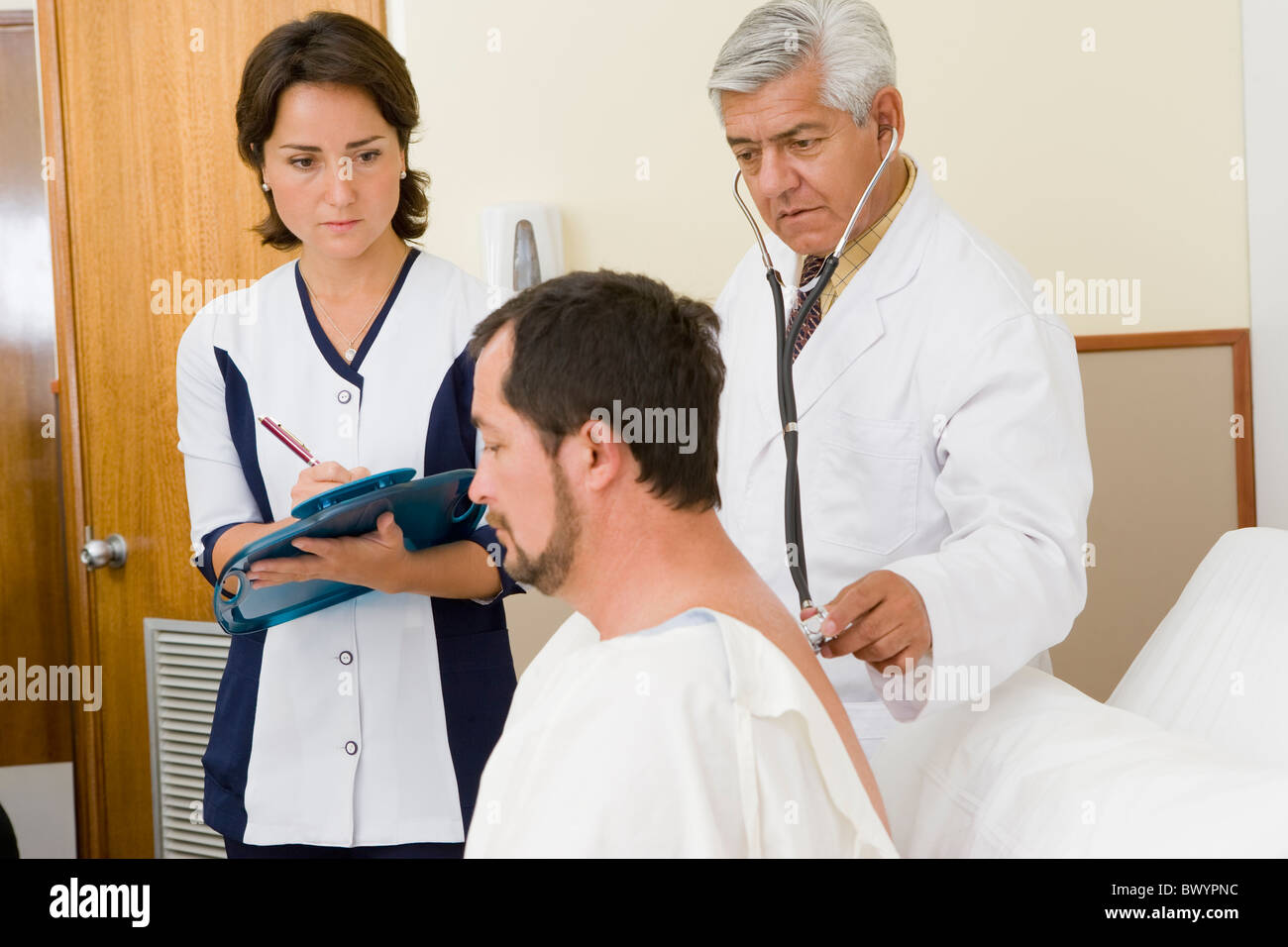 Doctor and nurse examining patient in hospital room Stock Photo - Alamy