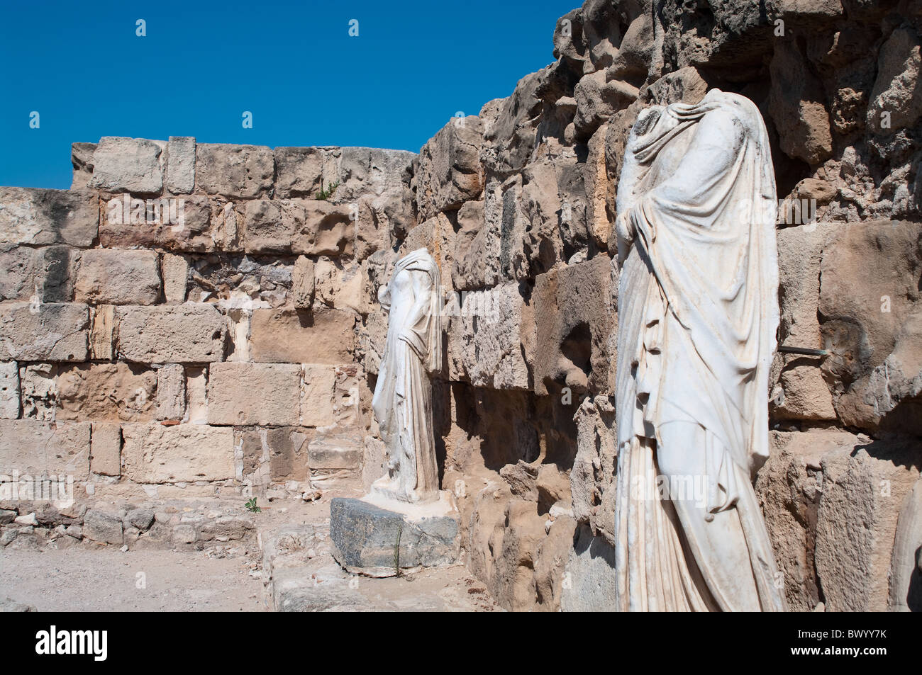 Roman ruins in Salamis ancient city in northern Cyprus. Two statues in ...